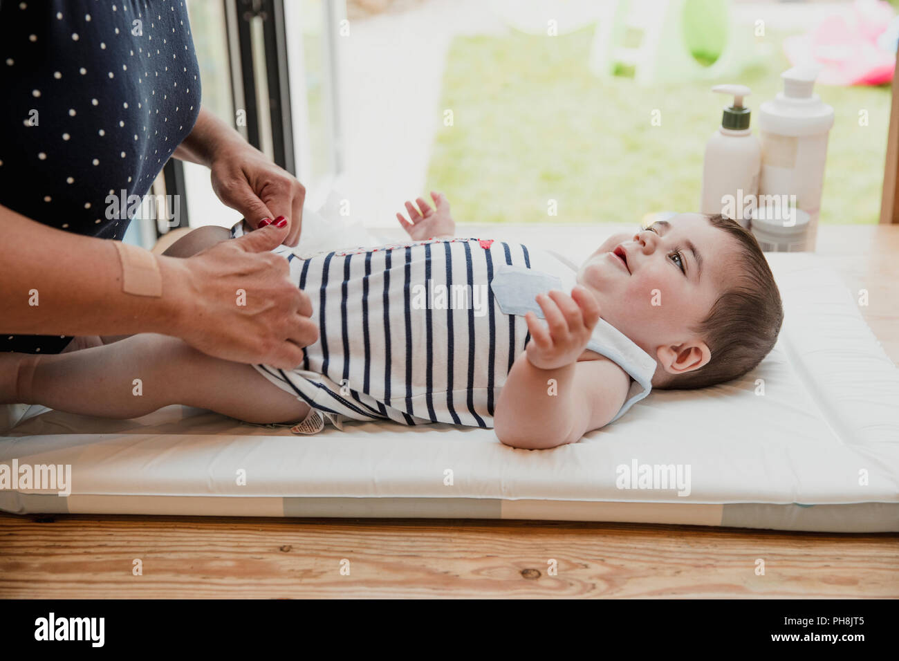 Side view of a baby boy lying on his back. The little boy is getting ...