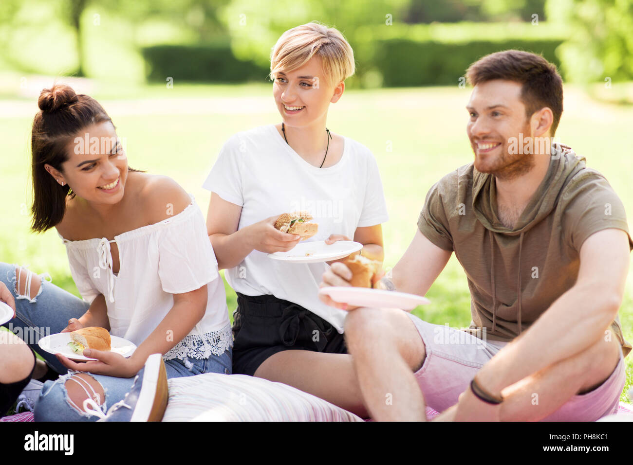 happy friends eating sandwiches at summer picnic Stock Photo - Alamy