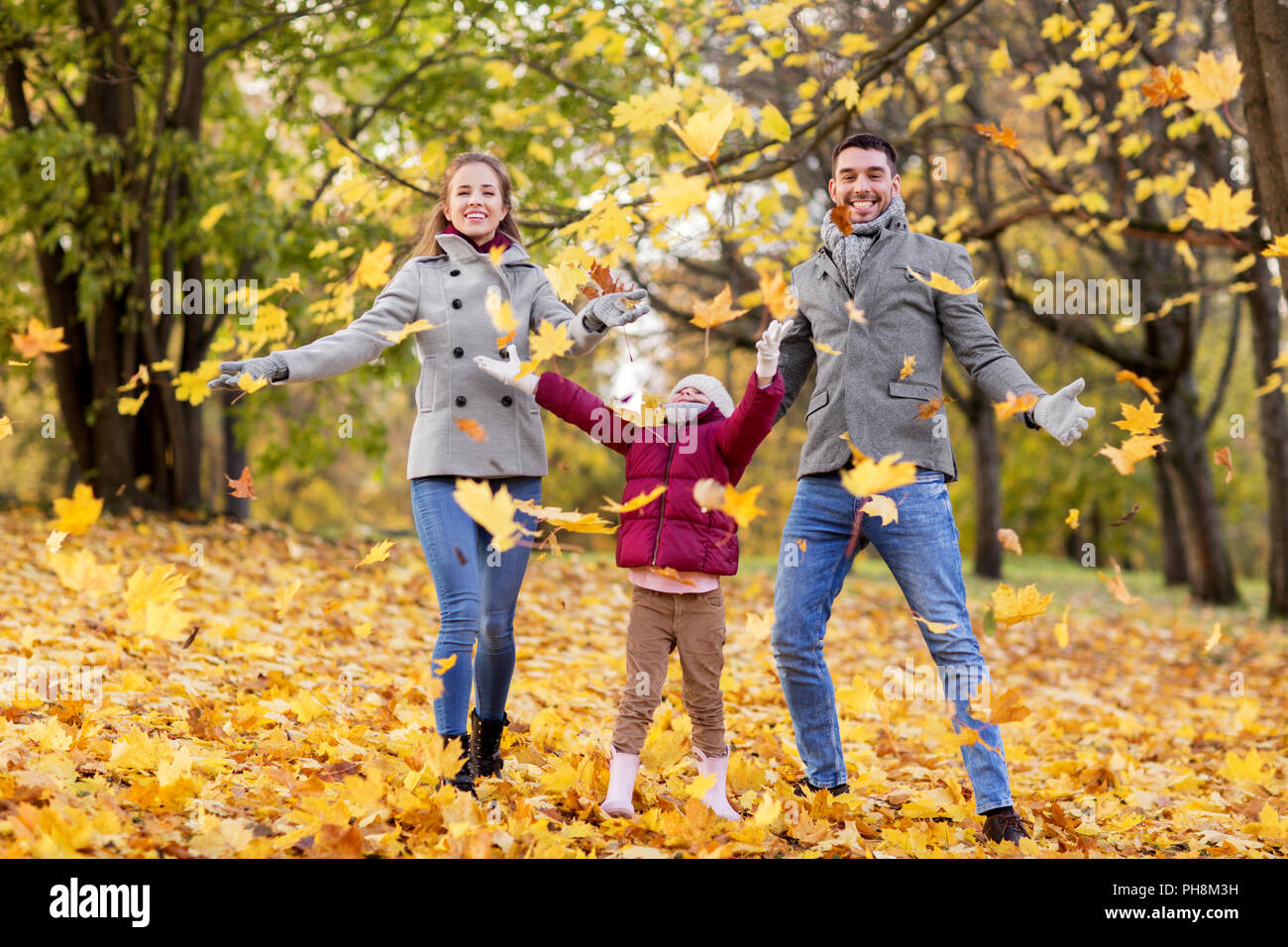 happy family playing with autumn leaves at park Stock Photo - Alamy