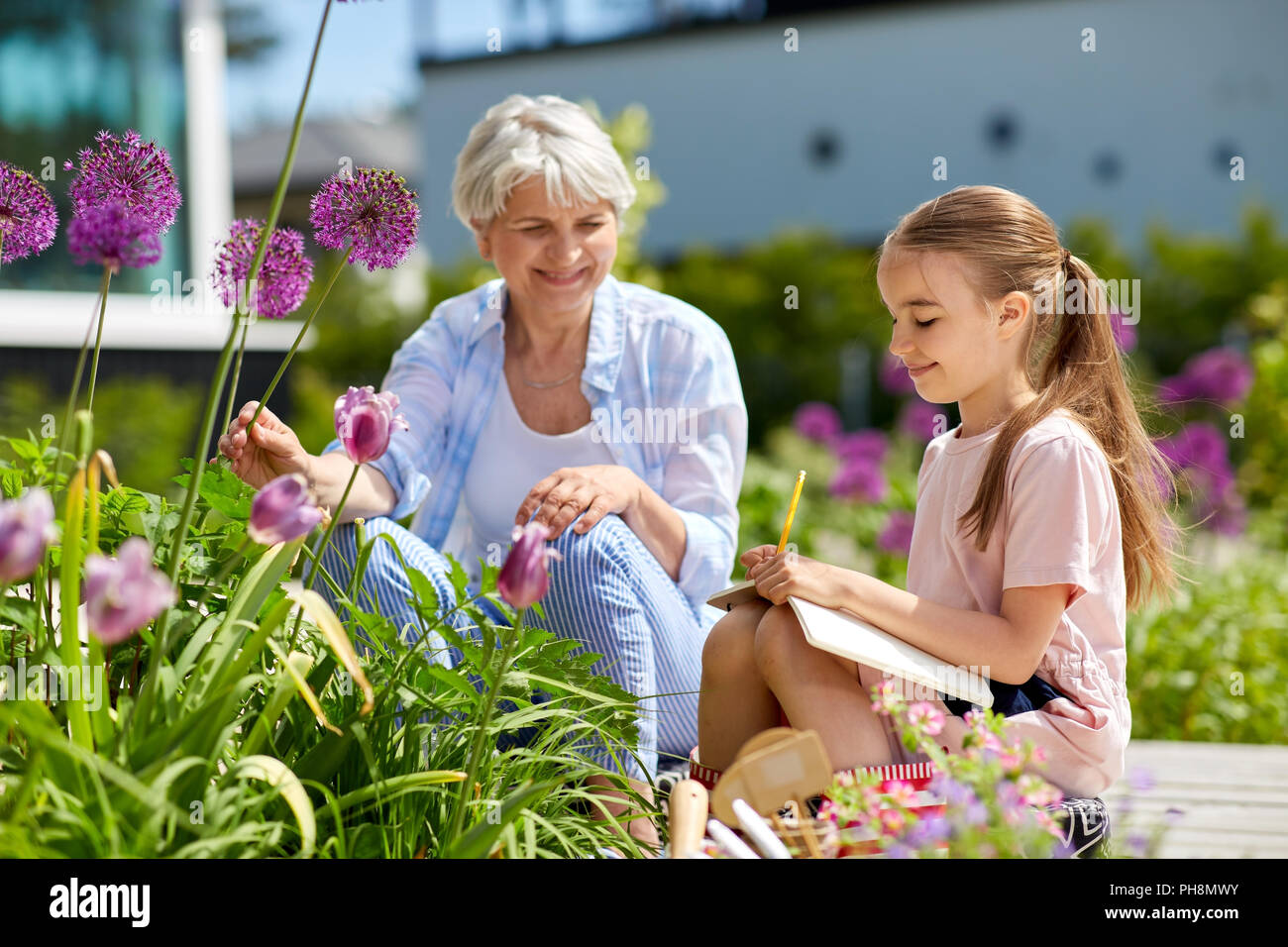 grandmother and girl study flowers at garden Stock Photo - Alamy