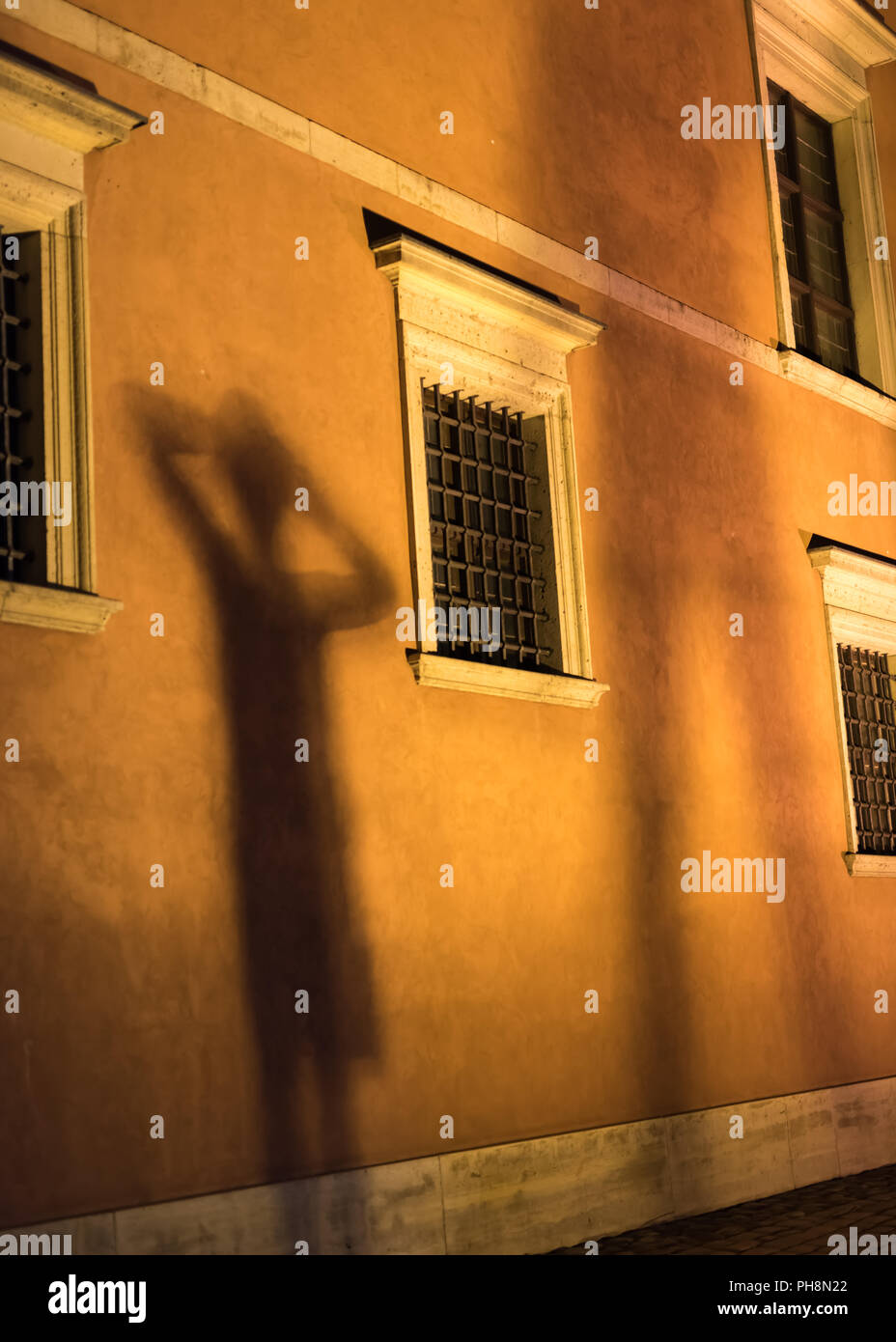 A shadow of a child standing in front of a facade at night Stock Photo ...