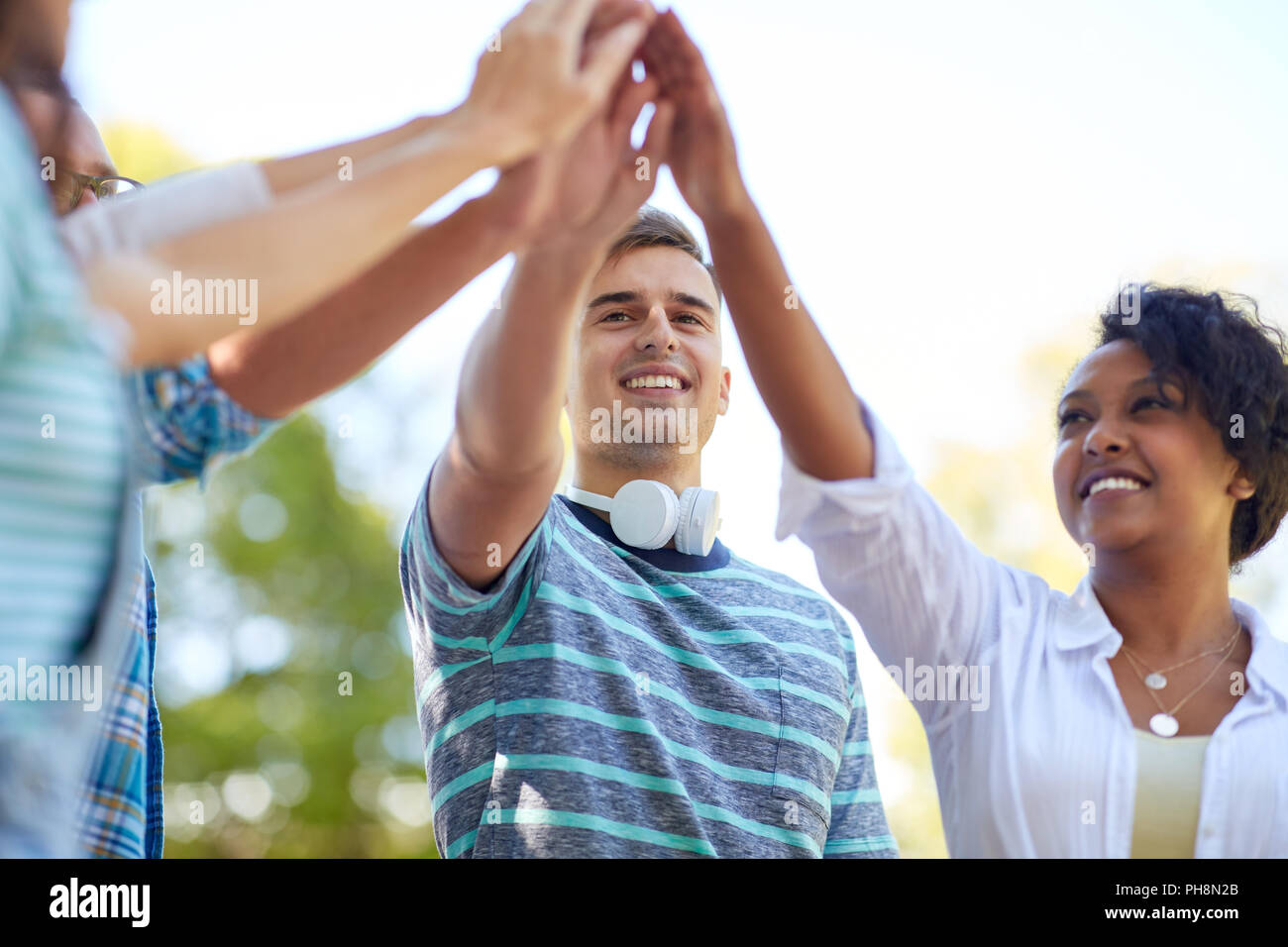 happy friends making high five in park Stock Photo - Alamy