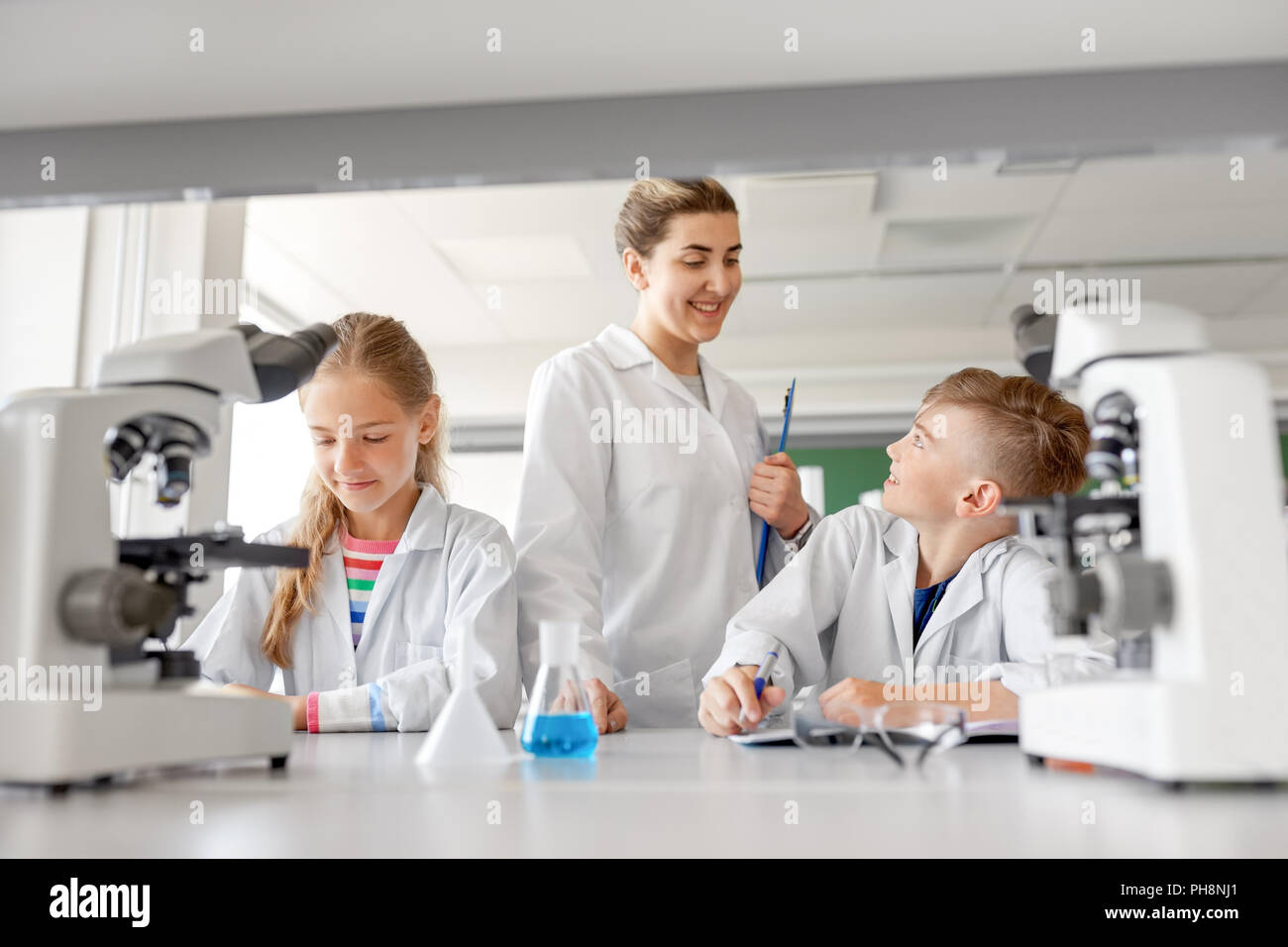 teacher and students studying chemistry at school Stock Photo - Alamy