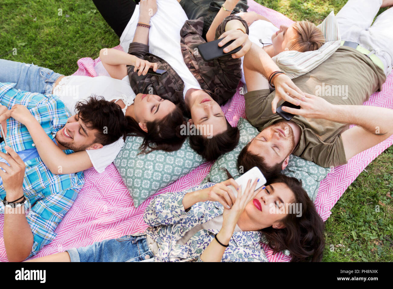 friends with smartphones on picnic blanket Stock Photo - Alamy
