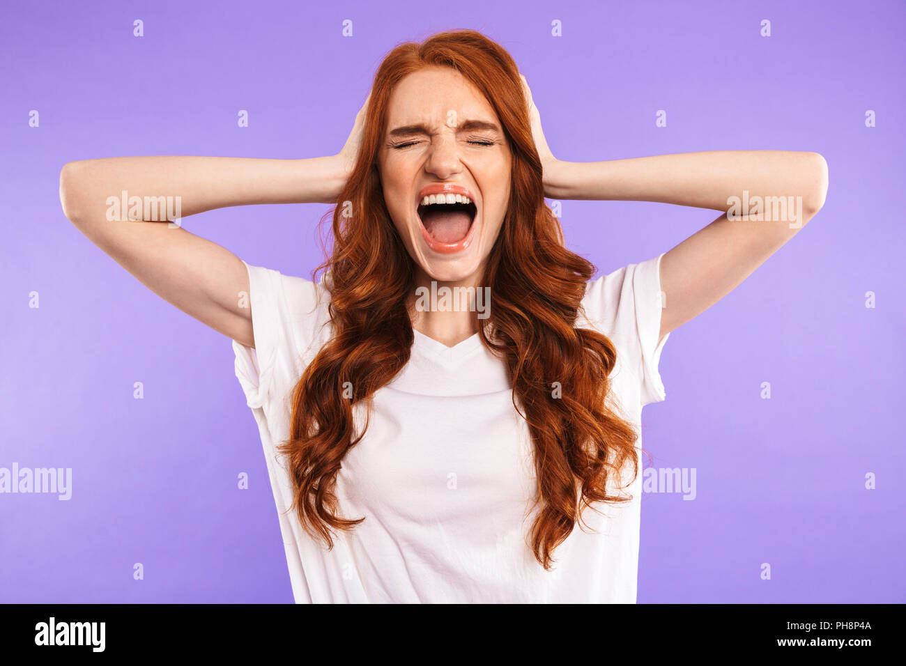 Portrait of an angry young girl isolated over violet background ...