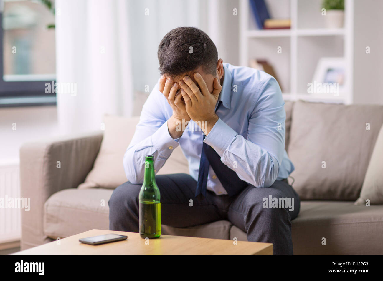 male alcoholic with bottle of beer at home Stock Photo - Alamy