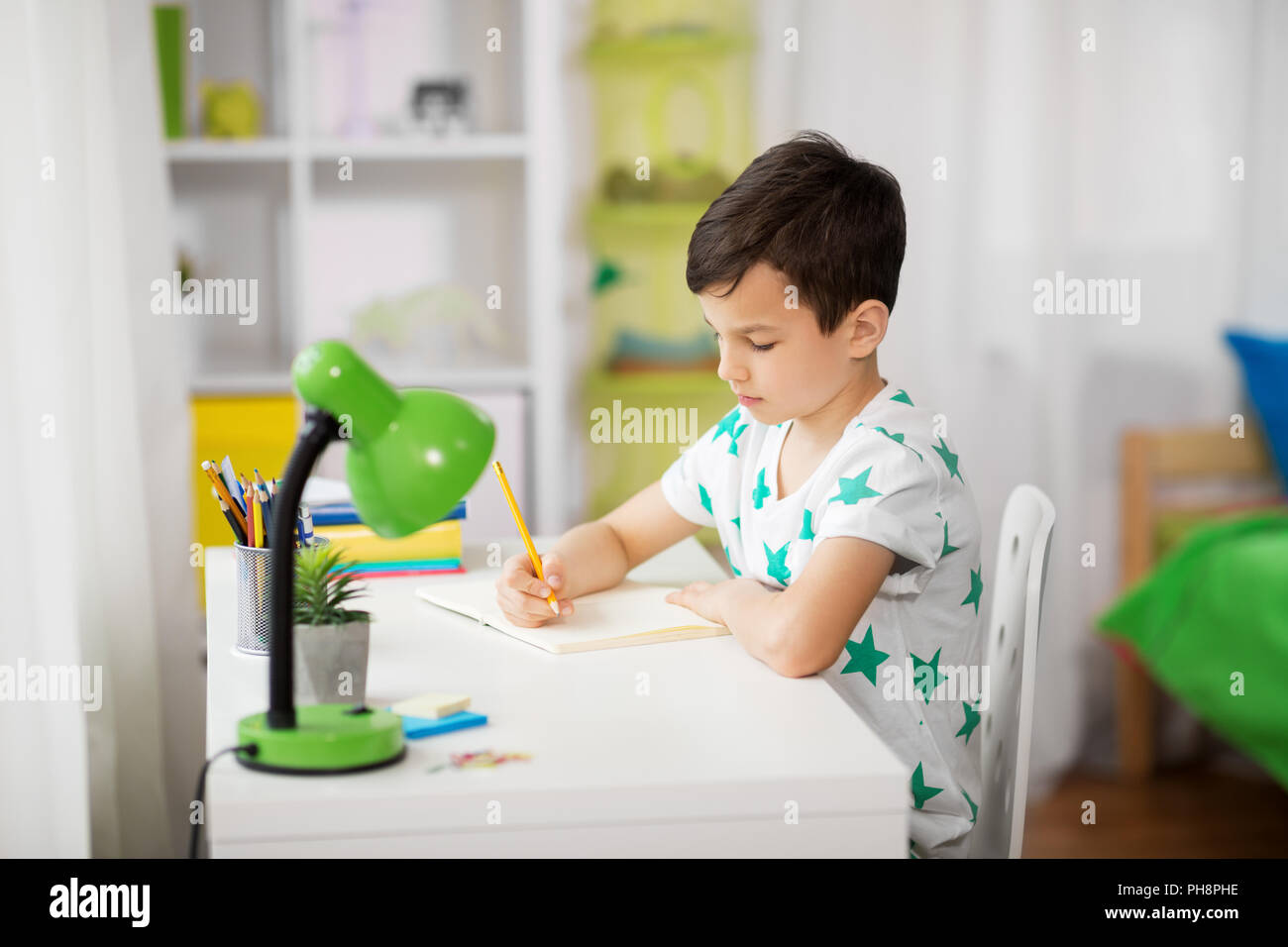 little boy writing to notebook at home Stock Photo - Alamy