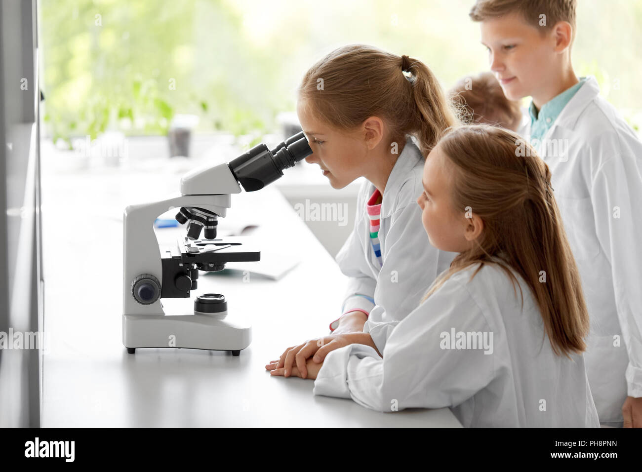 kids or students with microscope biology at school Stock Photo - Alamy