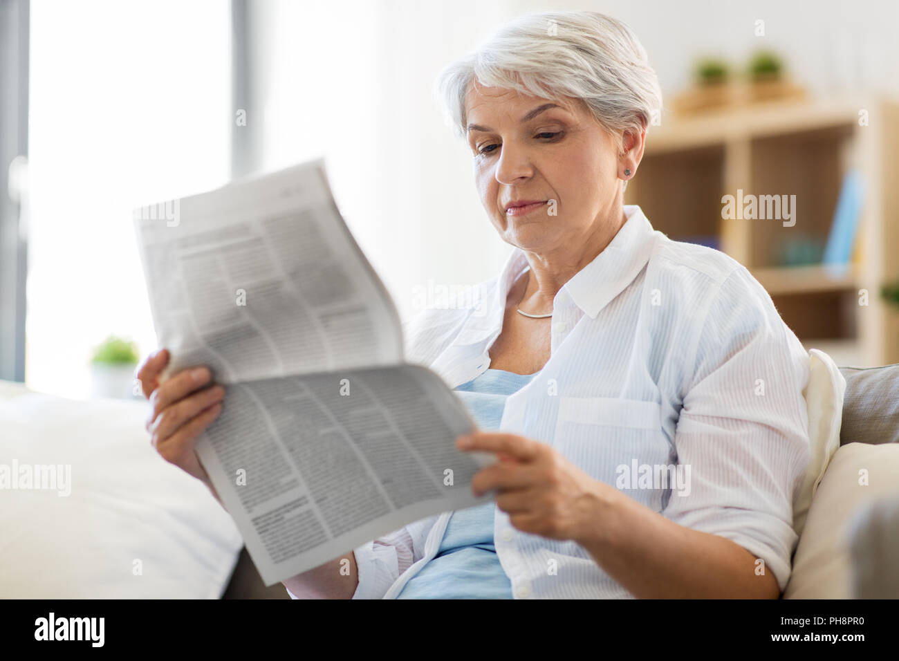 senior woman reading newspaper at home Stock Photo - Alamy