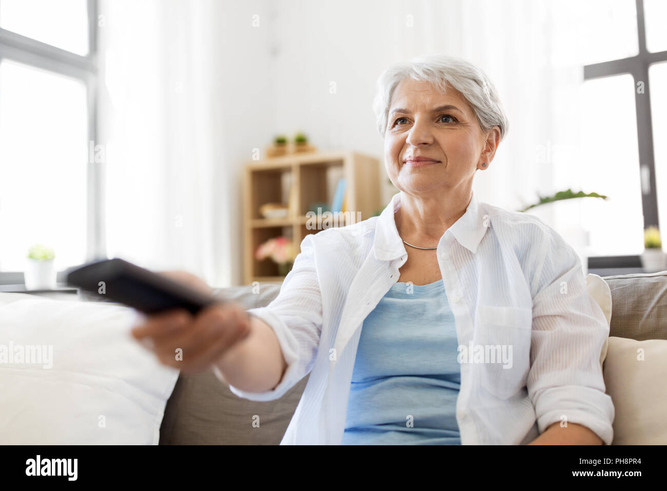 Beautiful mature woman watching tv hi-res stock photography and images ...