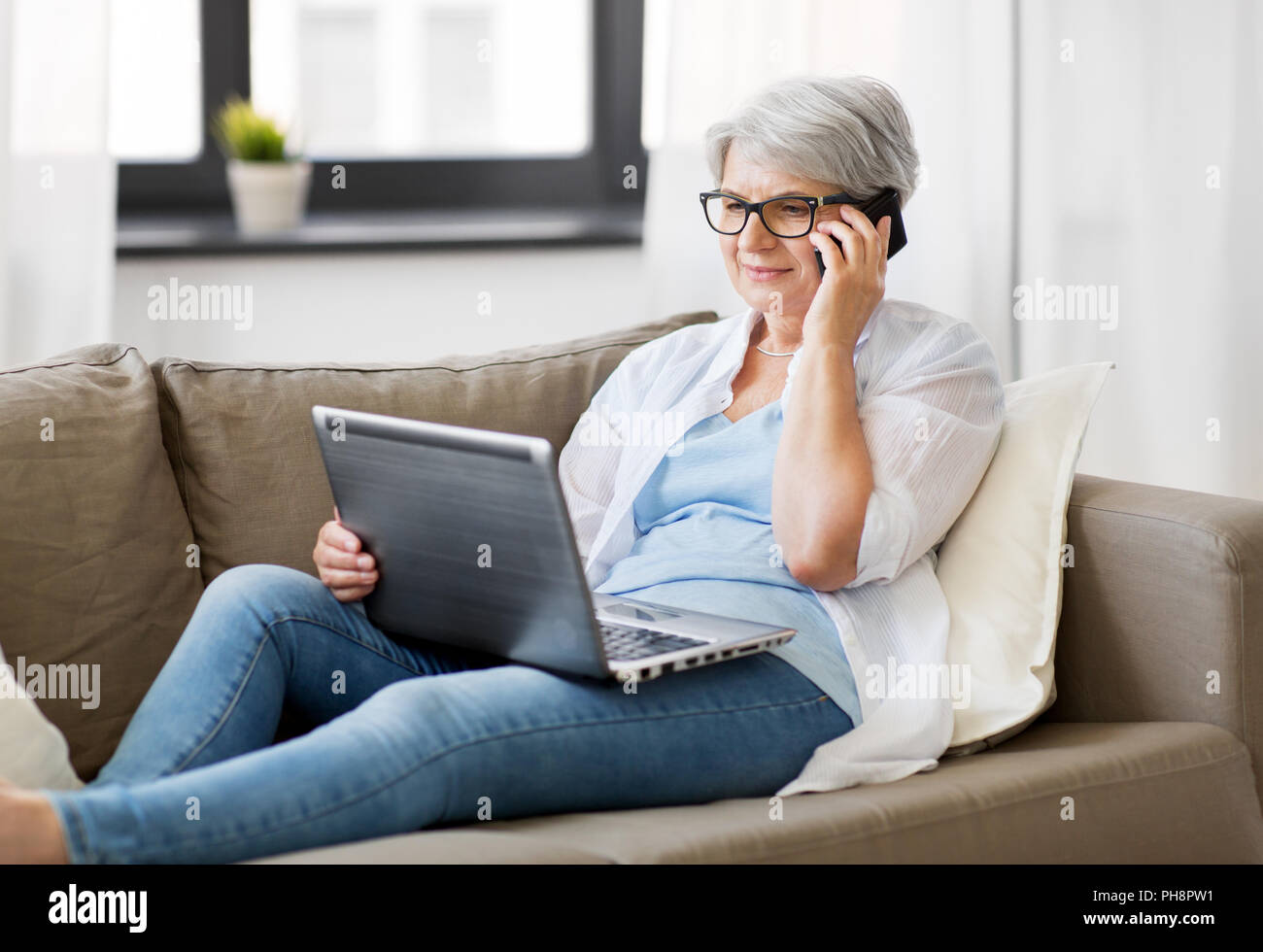 Senior woman laptop smartphone hi-res stock photography and images - Alamy