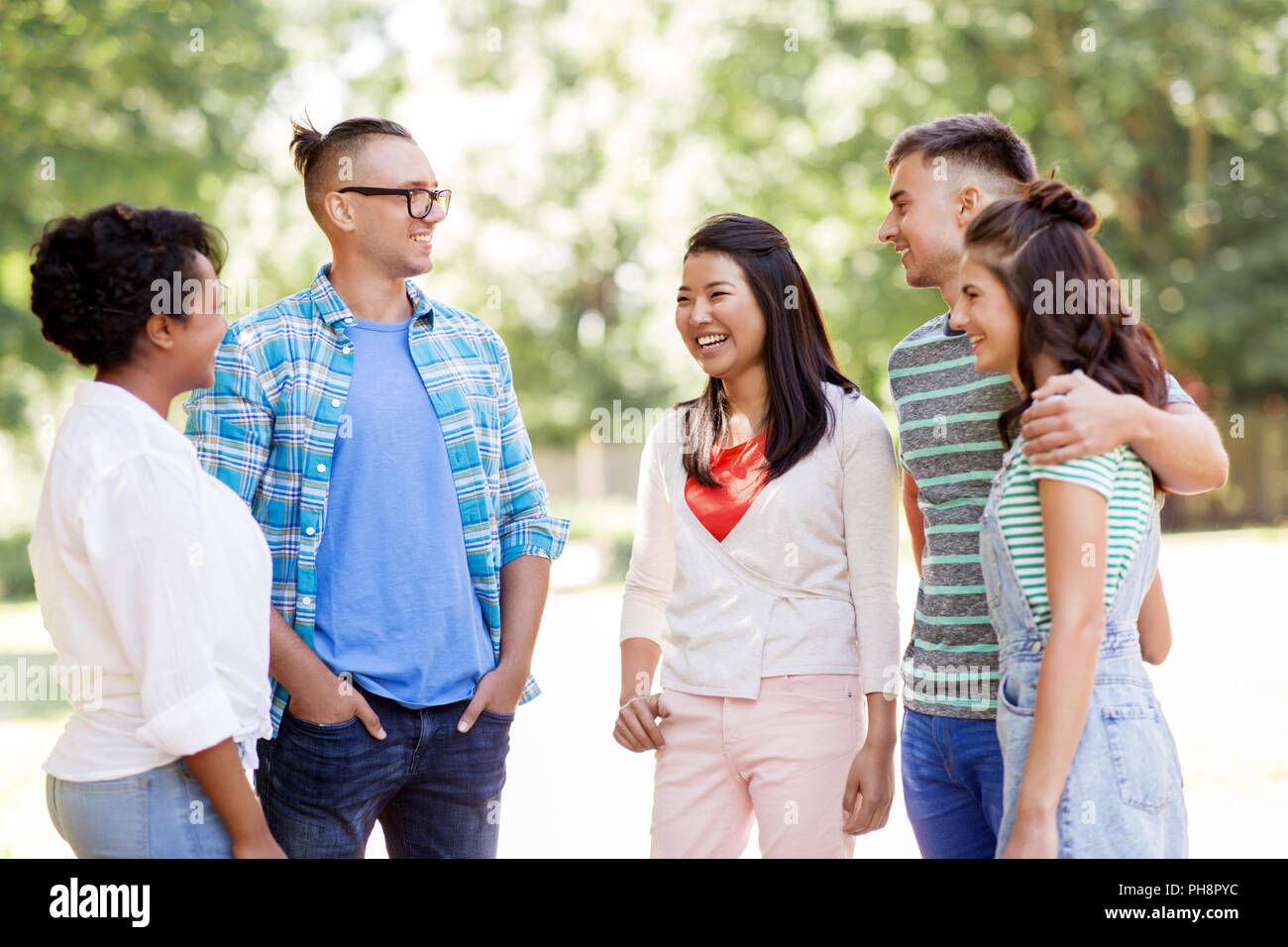 group of happy international friends in park Stock Photo - Alamy