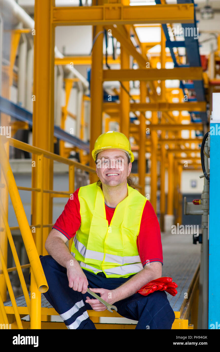 Factory worker resting in a factory and looking at a camera Stock Photo ...