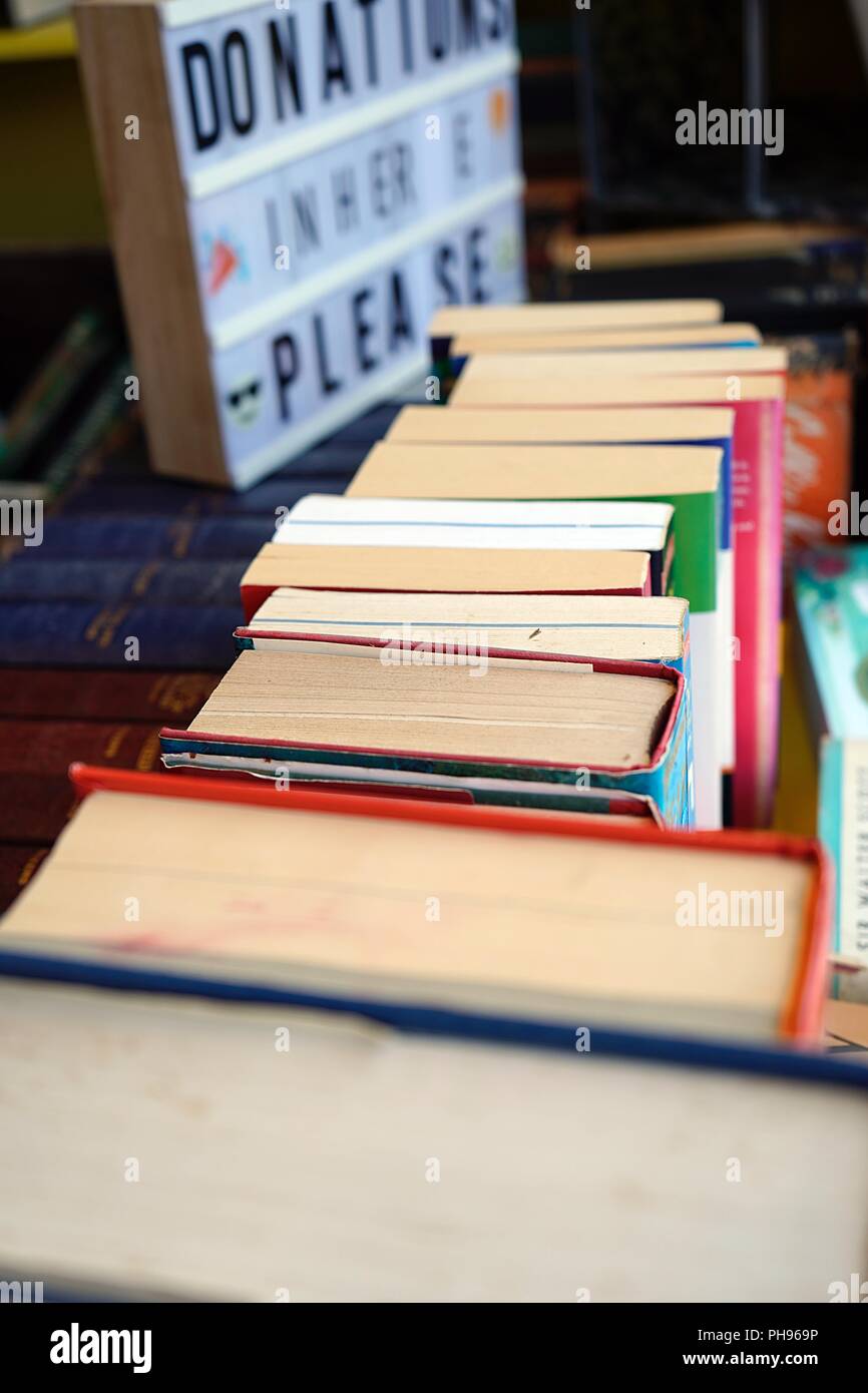 Second Hand Books lined up in a charity shop window with display sign ...