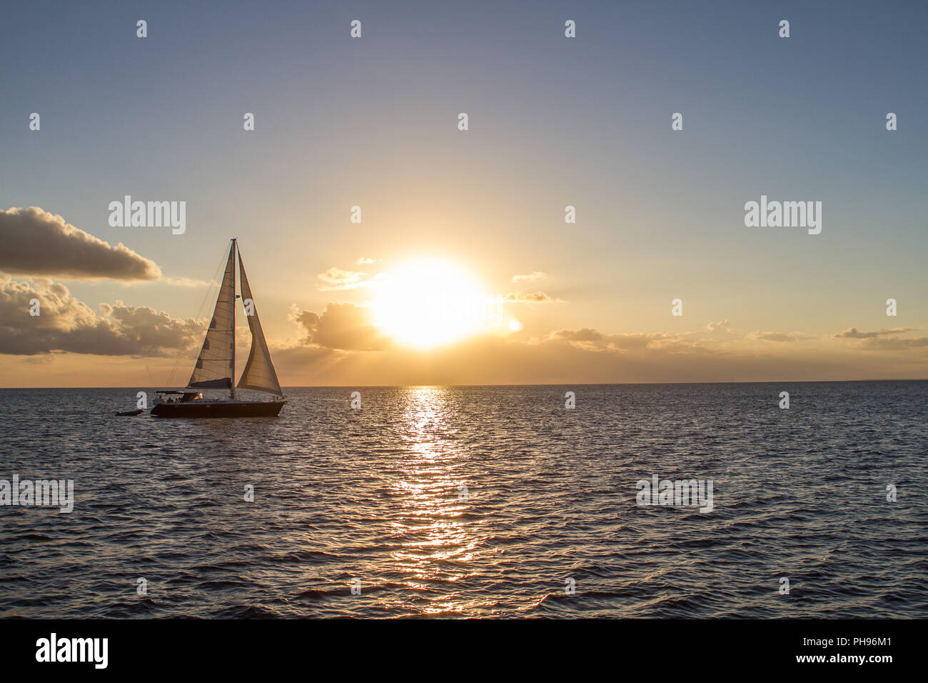 Yacht in the tropical sea at sunset Stock Photo - Alamy