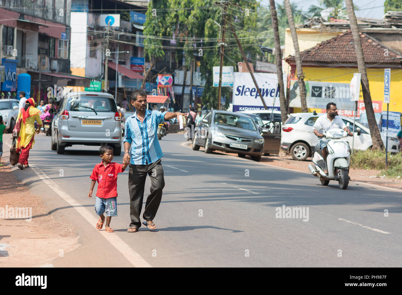 Goa, India - July 8, 2018 - Man with his boy on indian street in ...