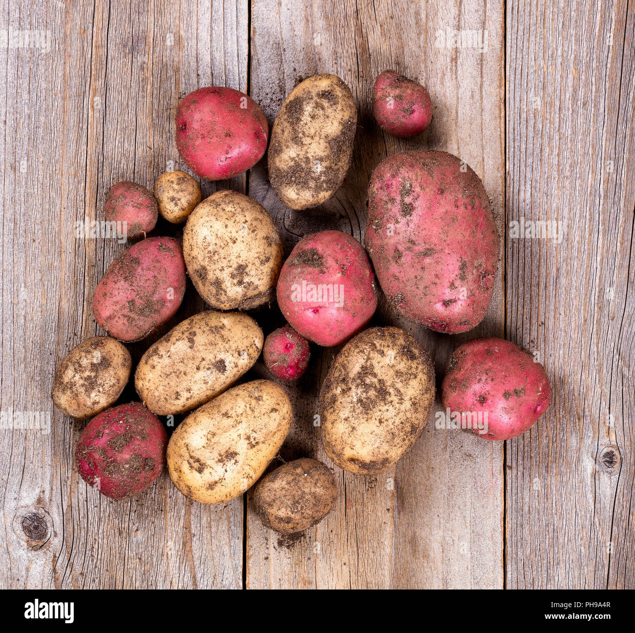 Raw uncleaned potatoes on rustic wooden boards Stock Photo - Alamy