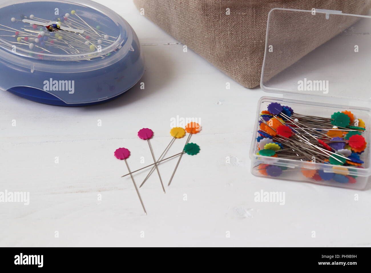 Decorative pins on white wooden surface Stock Photo - Alamy