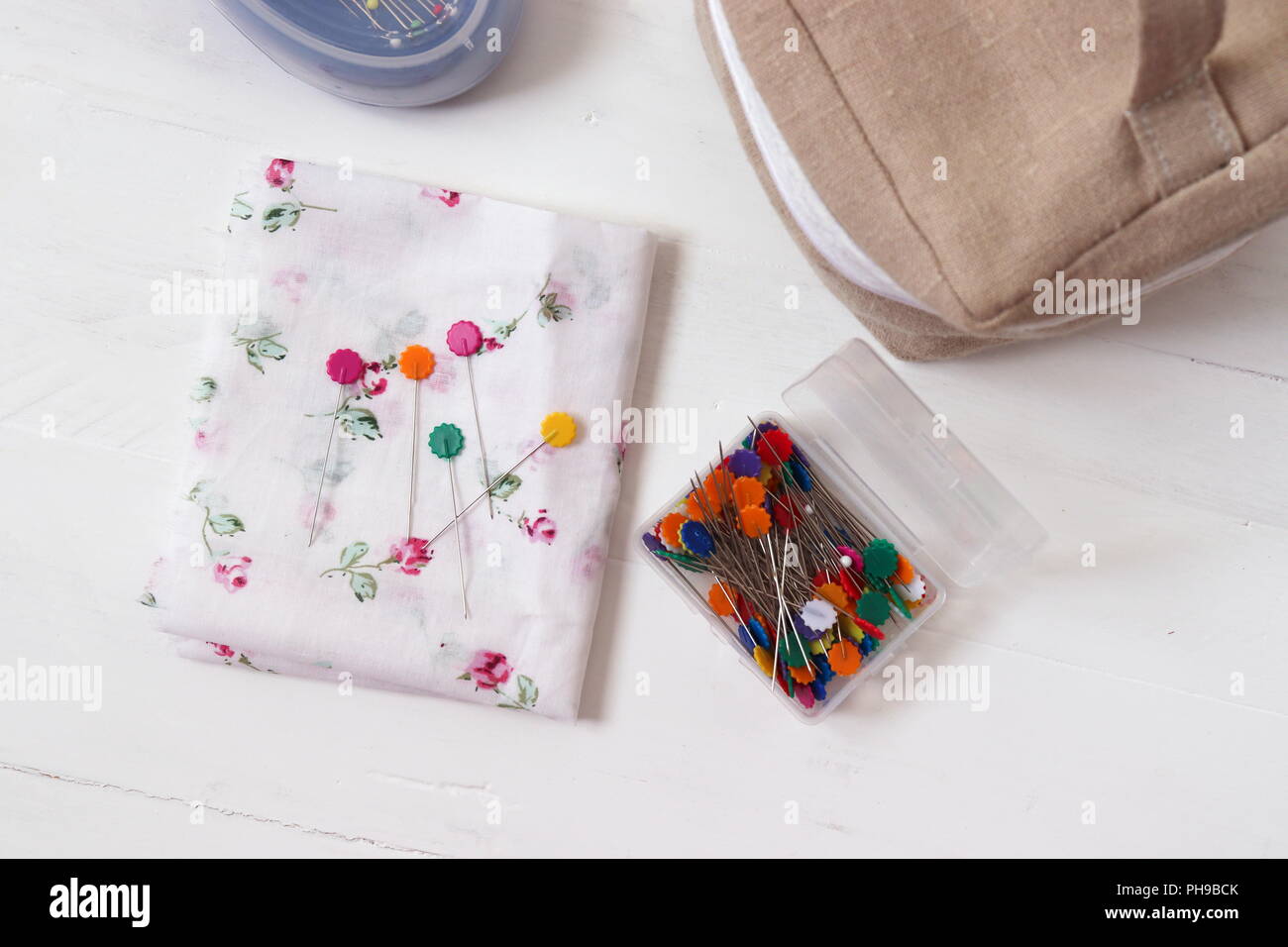 Decorative pins on white wooden surface Stock Photo - Alamy