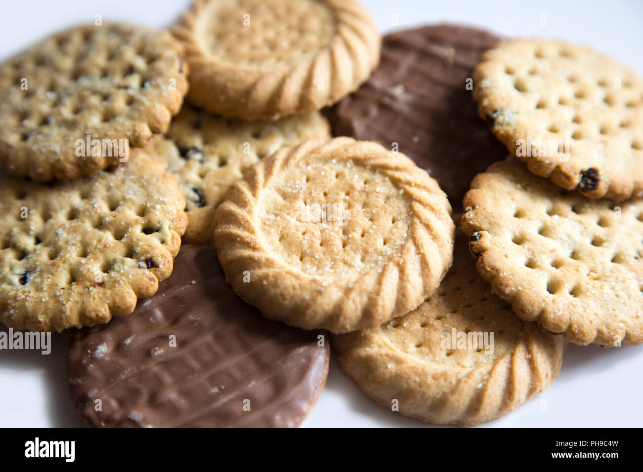 A pile of mixed biscuits ready to be eaten sitting on a clean white ...