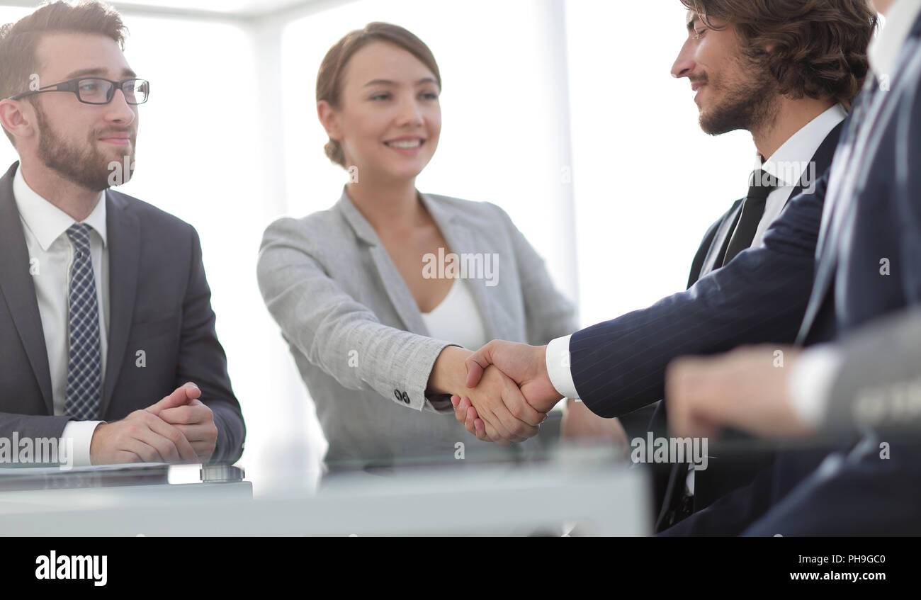 handshake business partners for their Desk Stock Photo - Alamy
