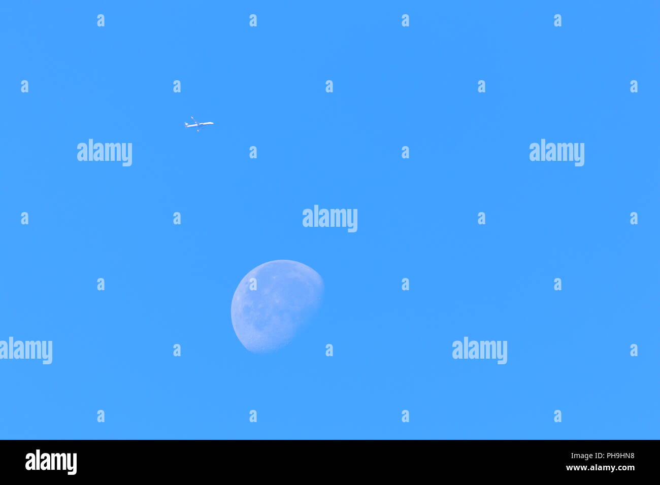 An aircraft passes in front of the Moon as it makes it's final approach ...