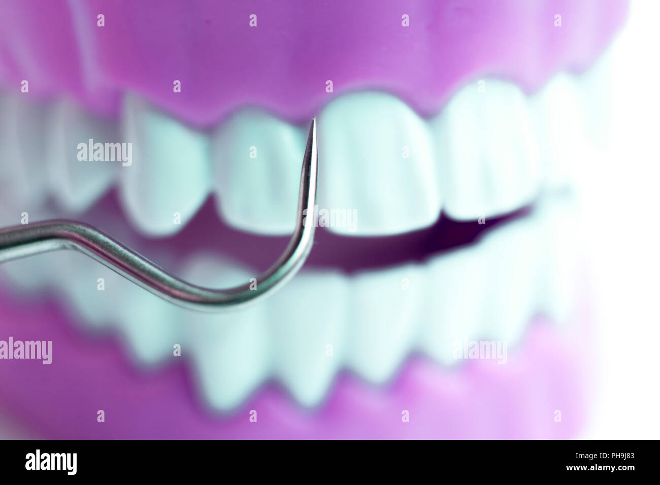 Dentist cleaning teeth with titanium metal tooth pick instrument to ...