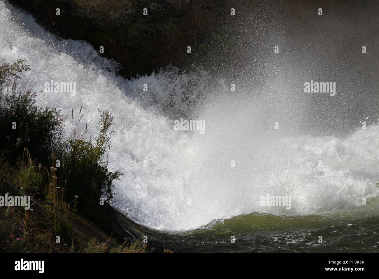 Dam wall and overflow of Iskar Dam. Water flowing over a dam wall. Mist ...