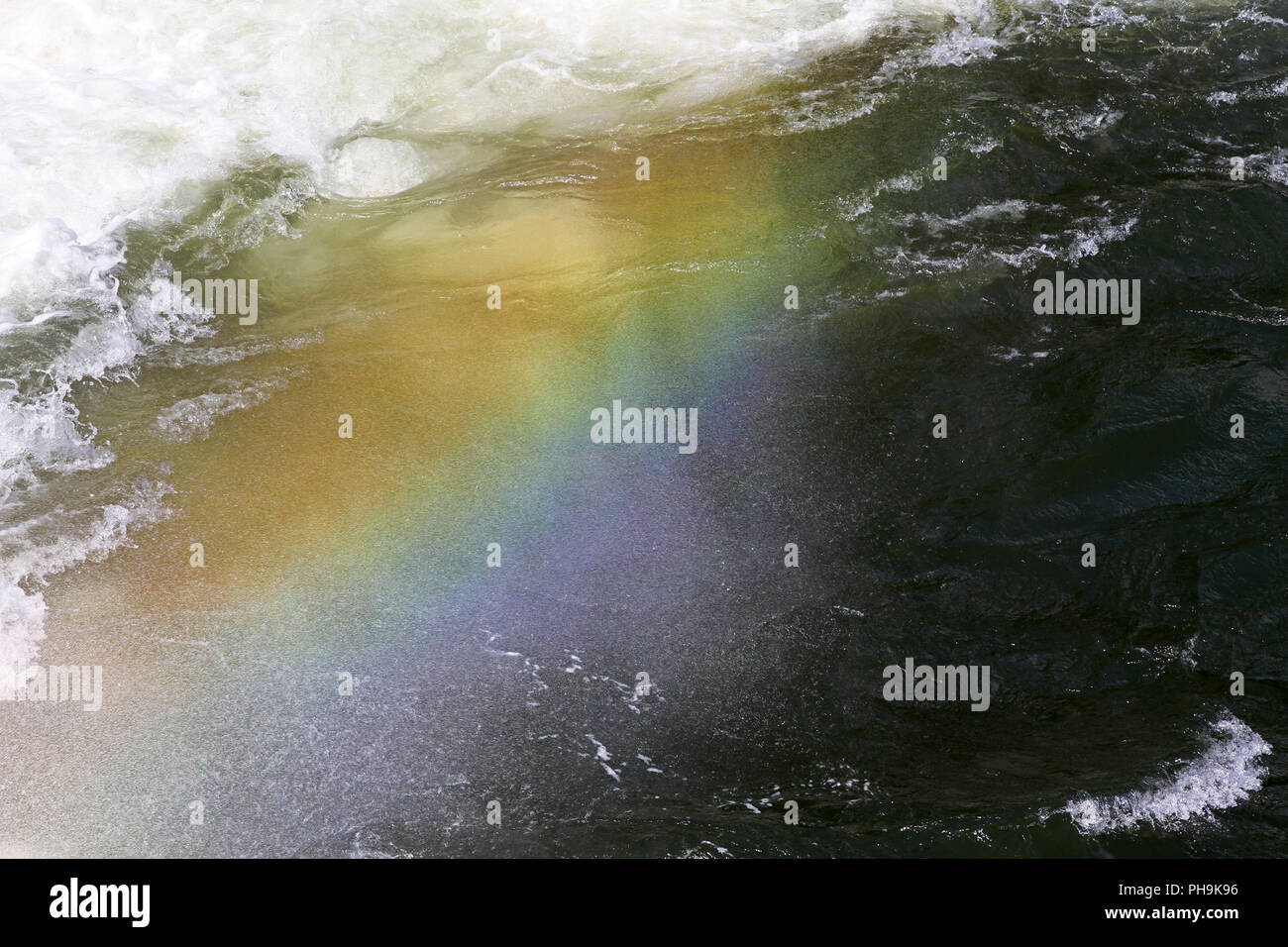 Rainbow water falls. Rainbow over waterfall in dam. Colorful rainbow in ...