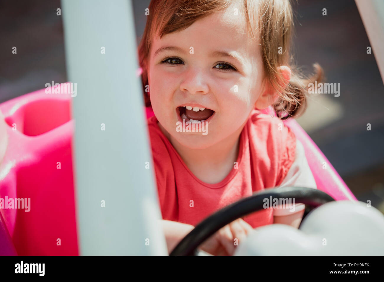 Little girl looking up at the camera and smiling with her mouth open ...