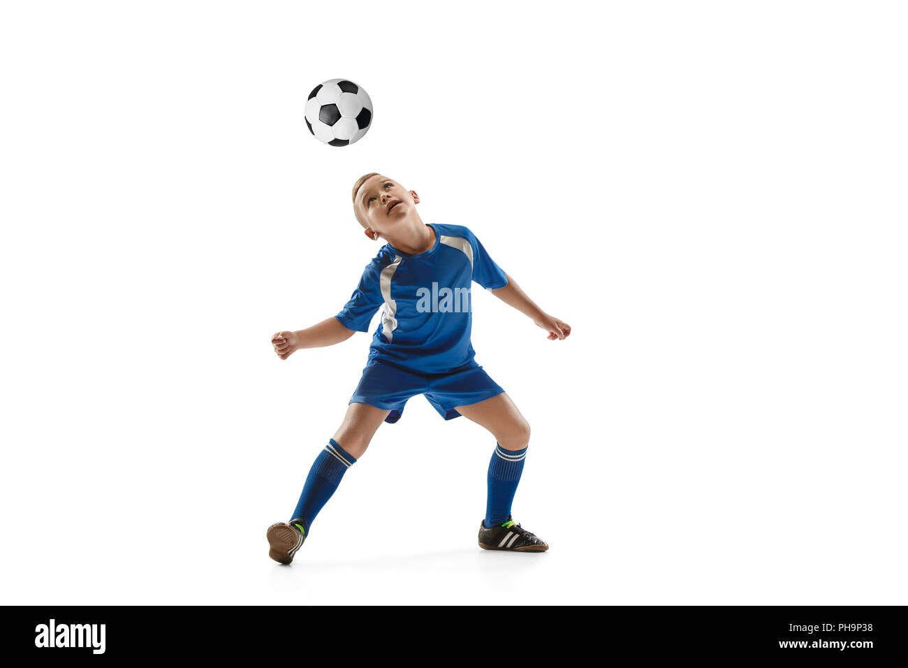Young boy with soccer ball doing flying kick, isolated on white ...