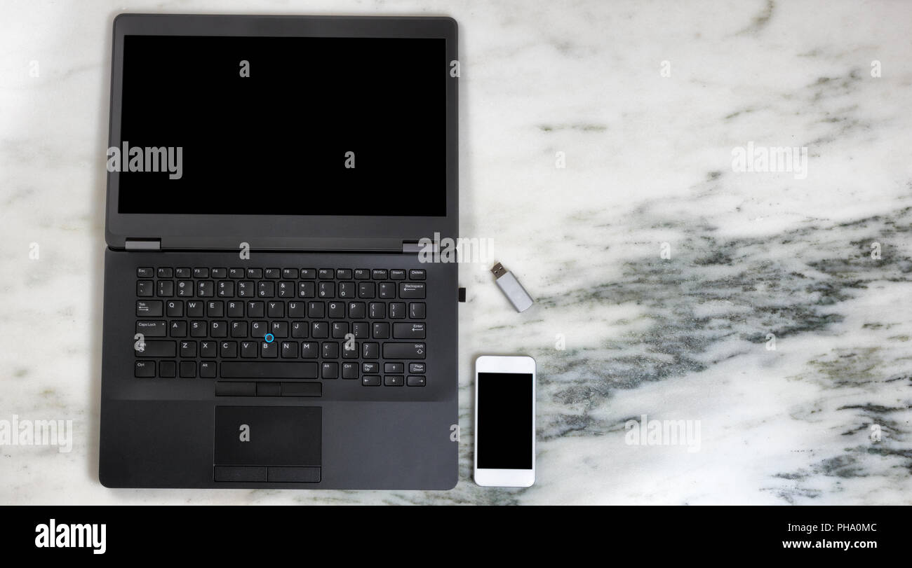 Modern mobile communication device and laptop computer on marble ...