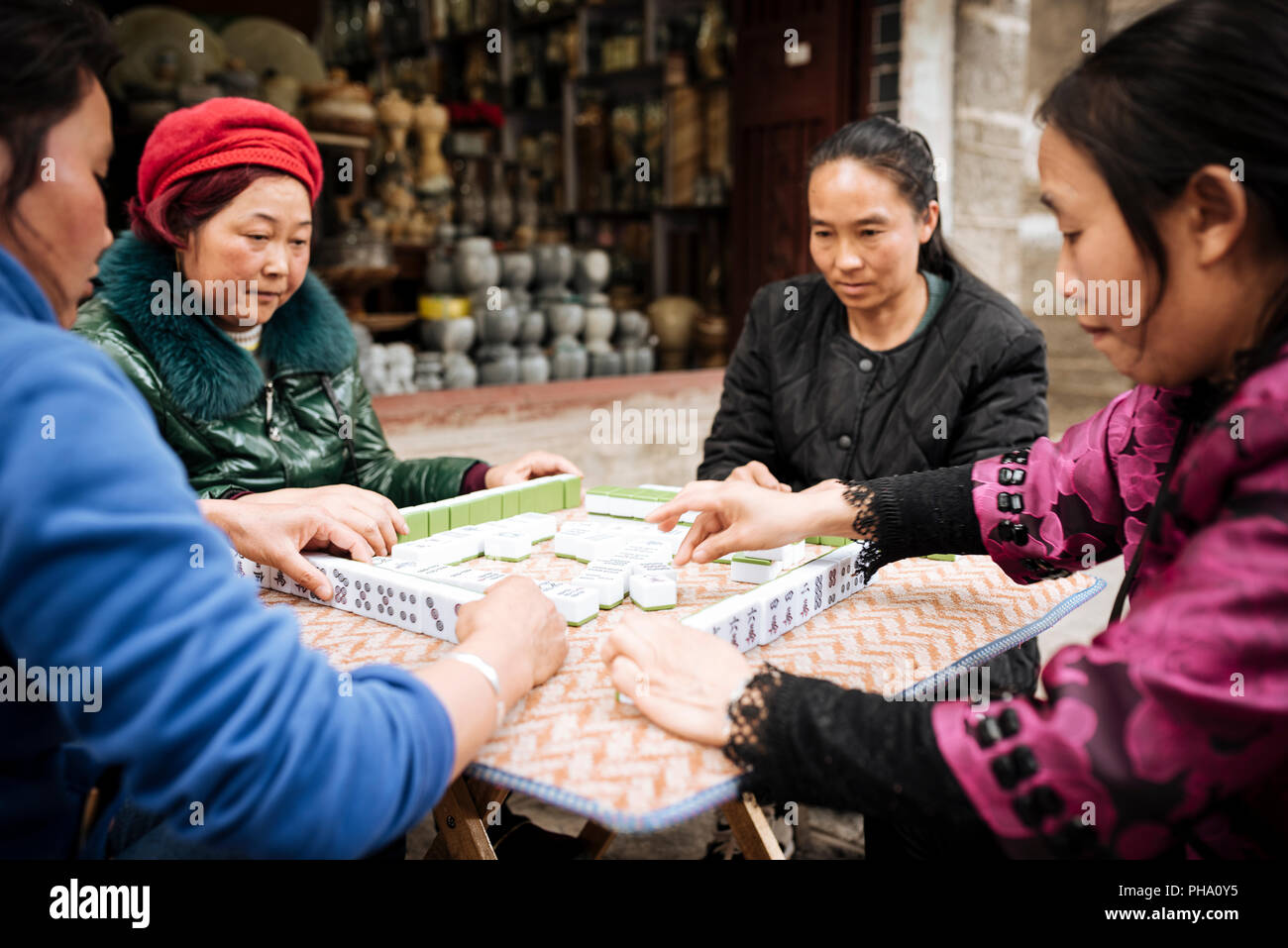 Women playing traditional Chinese game of Mahjong on street, Dali ...