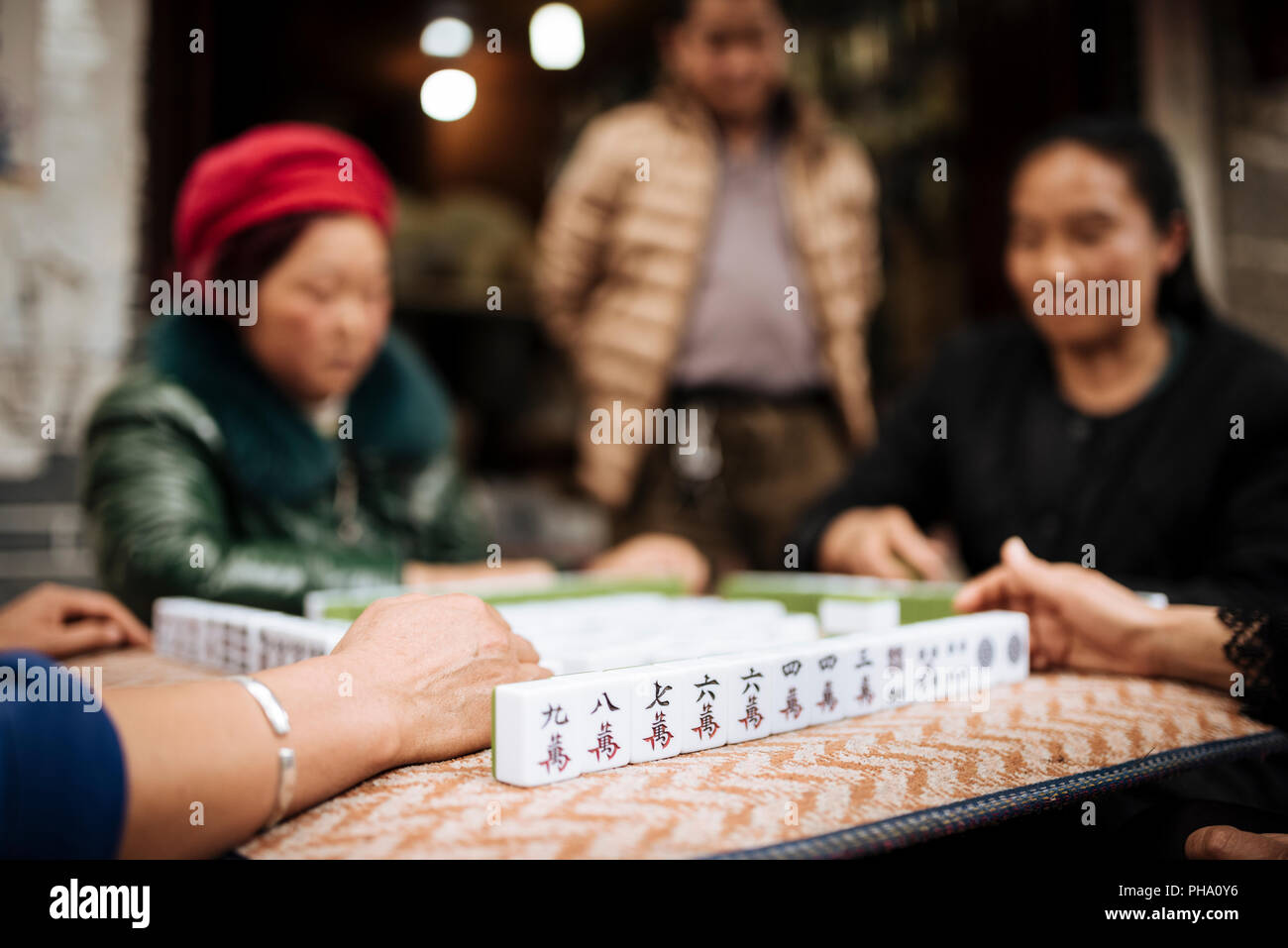 Women playing traditional Chinese game of Mahjong on street, Dali ...