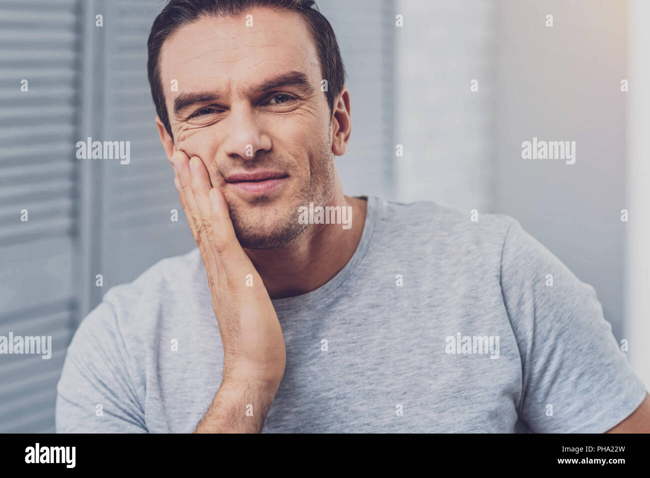 Man with bristle face touching his cheek Stock Photo - Alamy