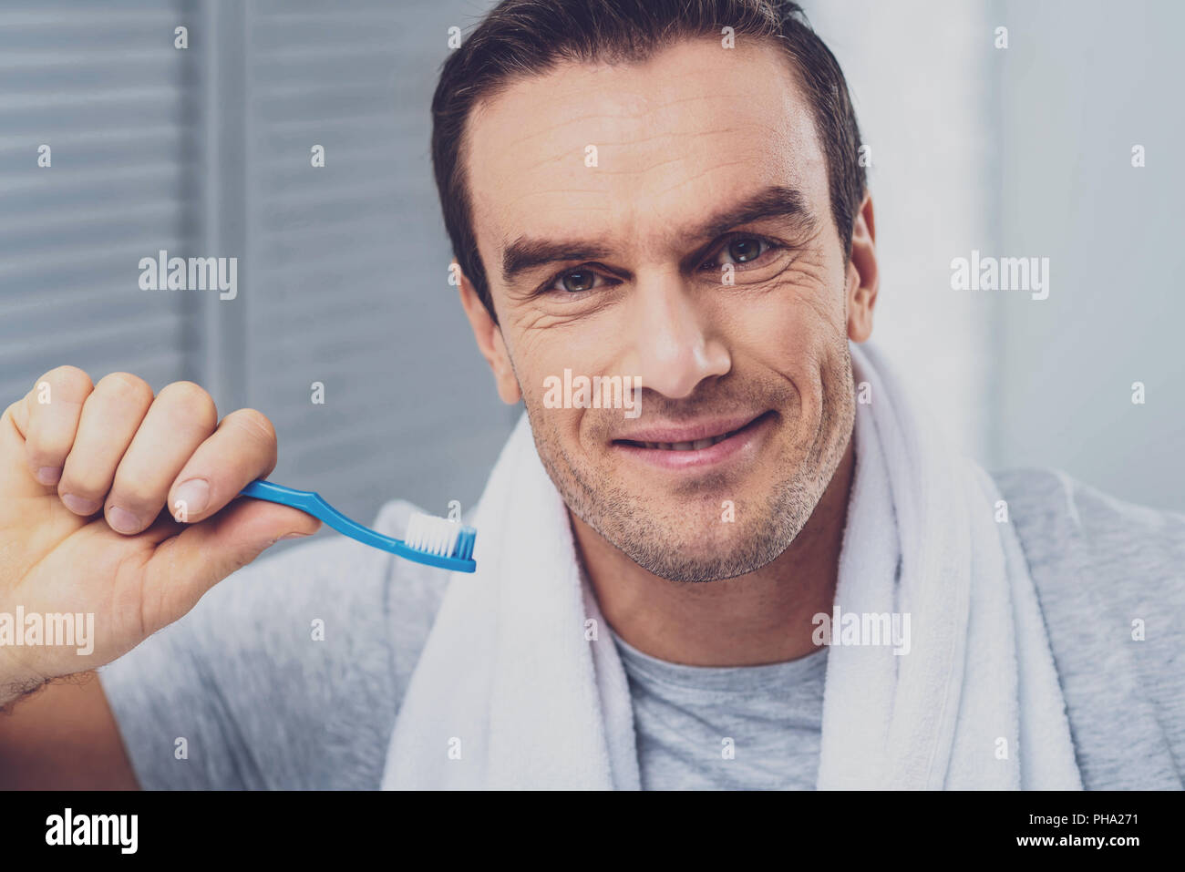 Hazel-eyed man holding toothbrush in his hand Stock Photo - Alamy