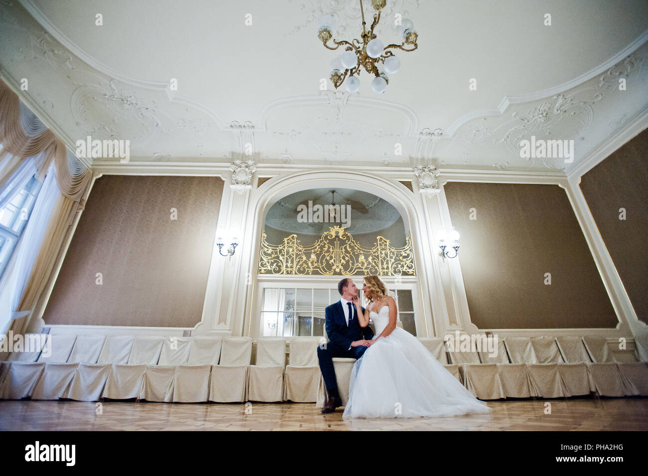 Beautiful blonde bride with groom at grand palace Stock Photo - Alamy