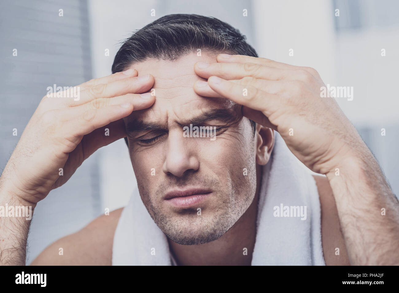 Concentrated man touching forehead with his hands Stock Photo - Alamy