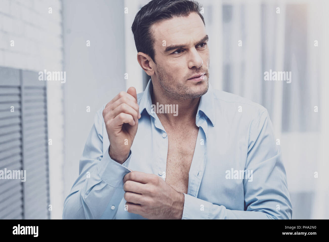 Confident office worker putting on a shirt Stock Photo - Alamy