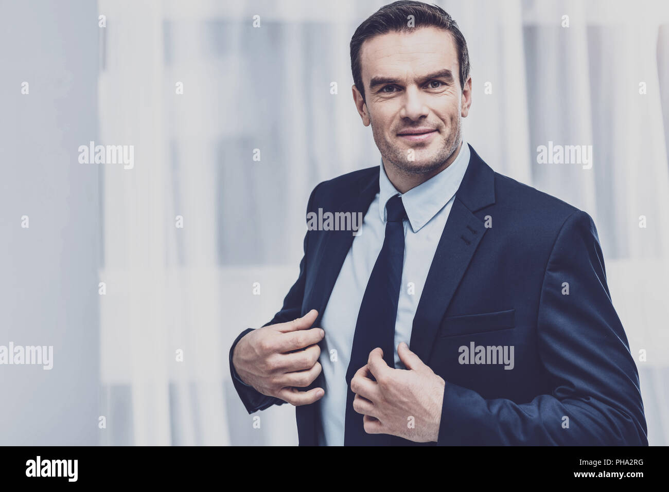Professional manager putting on jacket Stock Photo - Alamy