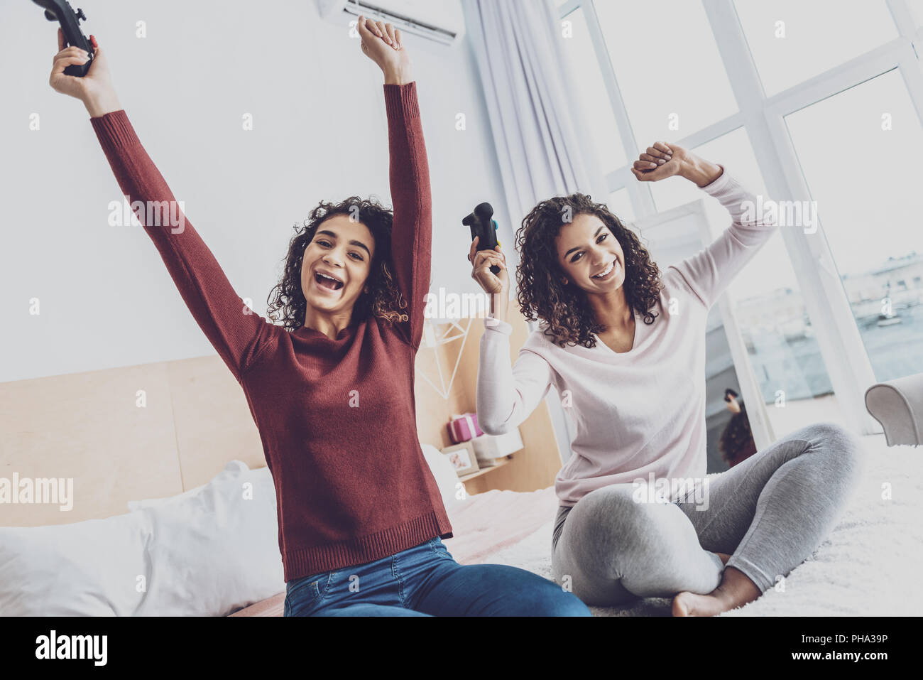 Positive delighted females celebrating win Stock Photo - Alamy