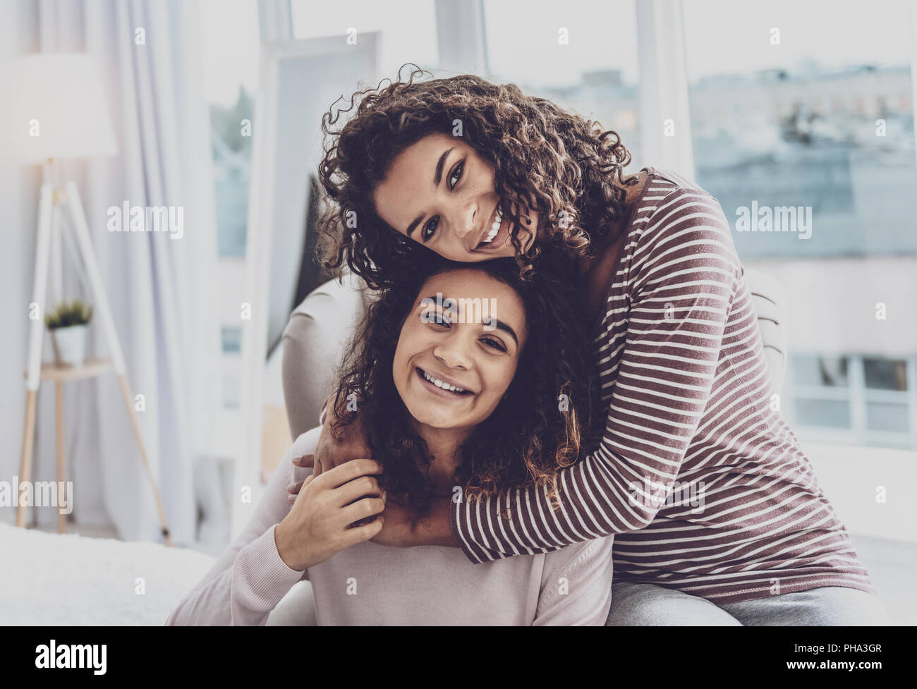 Happy girls posing on camera Stock Photo - Alamy