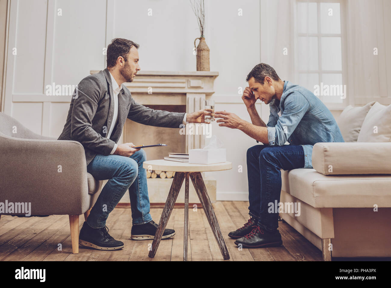 Serious therapist calming his patient Stock Photo - Alamy