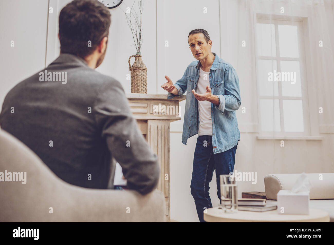 Serious visitor explaining his life situation Stock Photo - Alamy