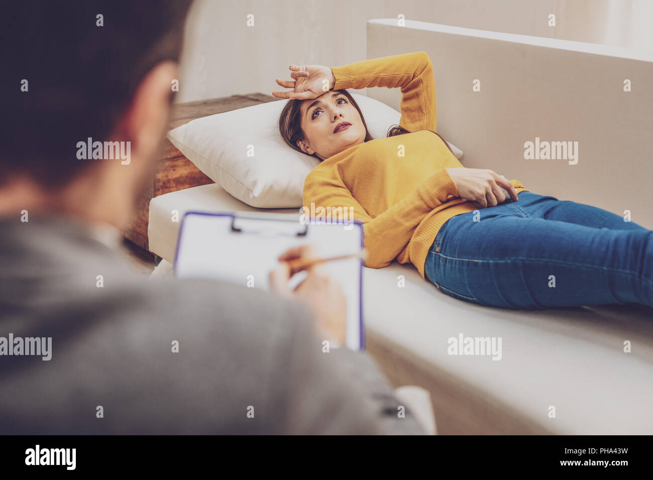 Pretty upset woman visiting psychologist Stock Photo - Alamy