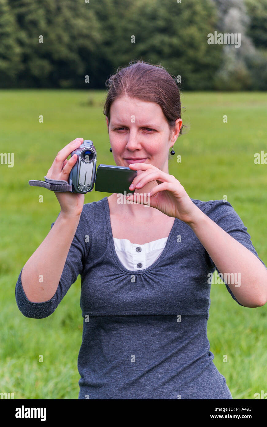 Young woman filming with a camcorder/ handycam Stock Photo - Alamy