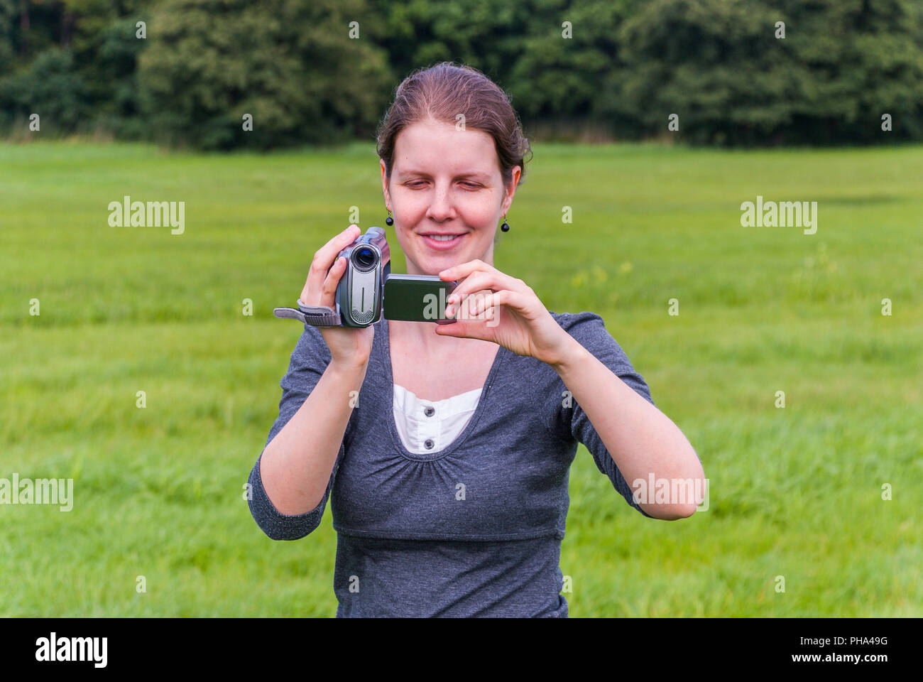 Young woman filming with a camcorder/ handycam Stock Photo - Alamy