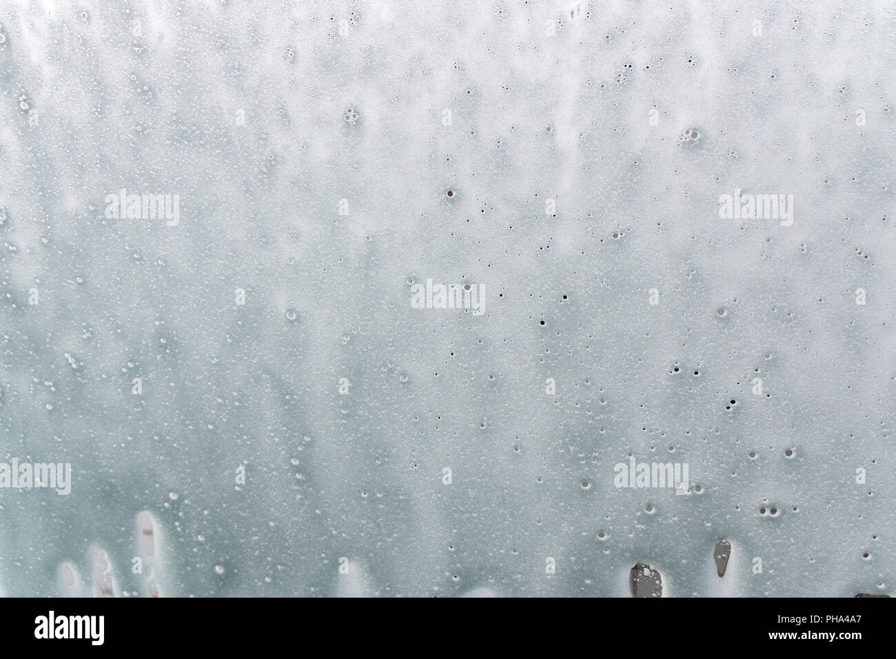 A close up veiw from the inside of a glass window that has soap foam ...