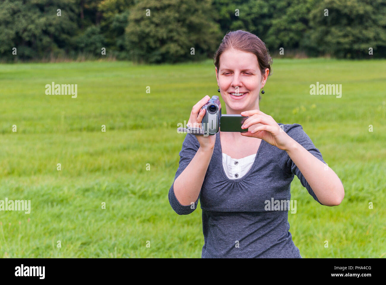Young woman filming with a camcorder/ handycam Stock Photo - Alamy