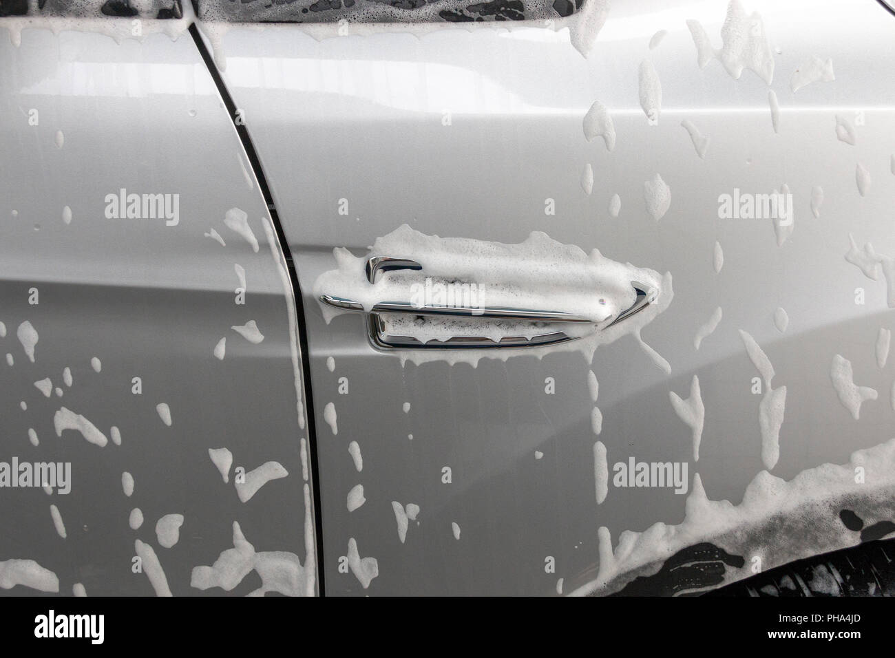 A Close up view of soap foam running off the front side of a sliver car ...